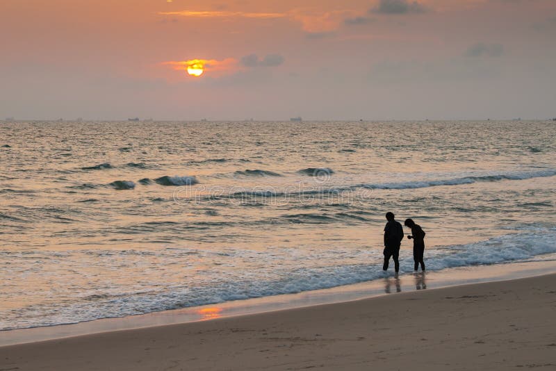 Silhouettes of Two People Standing on the Beach Stock Photo - Image of ...