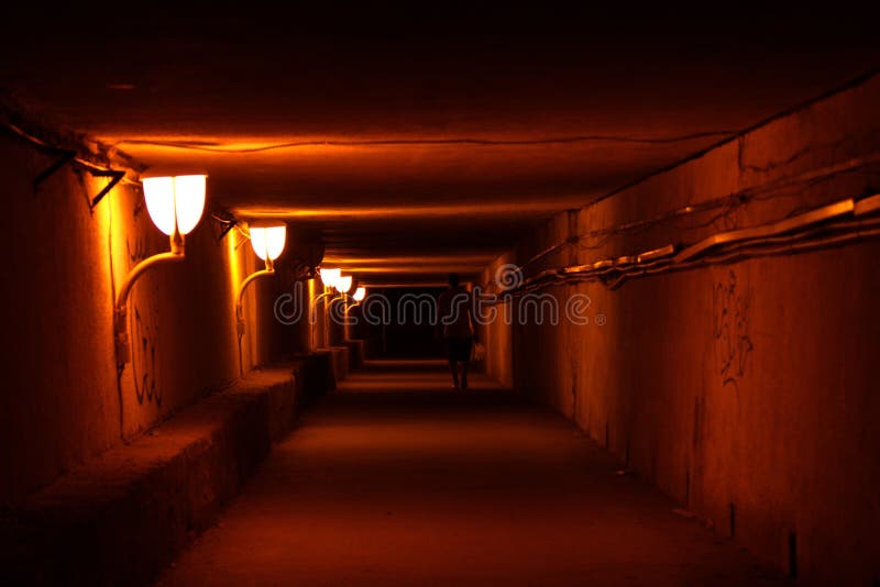 Silhueta De Um Homem Que Atravessa a Passagem Iluminada Por Lanternas ... Silhueta De Um Homem Que Atravessa a Passagem Iluminada Por Lanternas ...