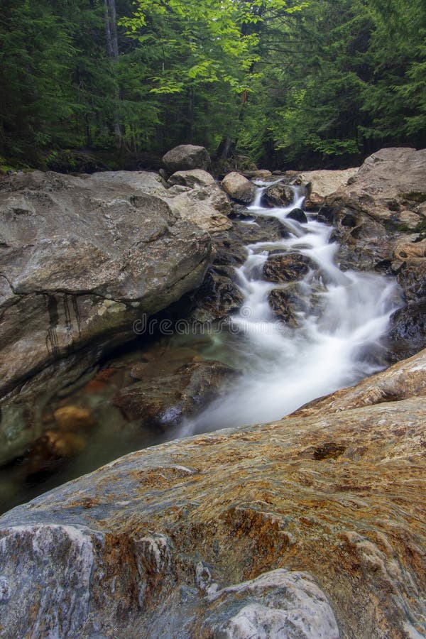 Silky Smooth Water Flowing Over Rocks through the Forest Stock Photo ...