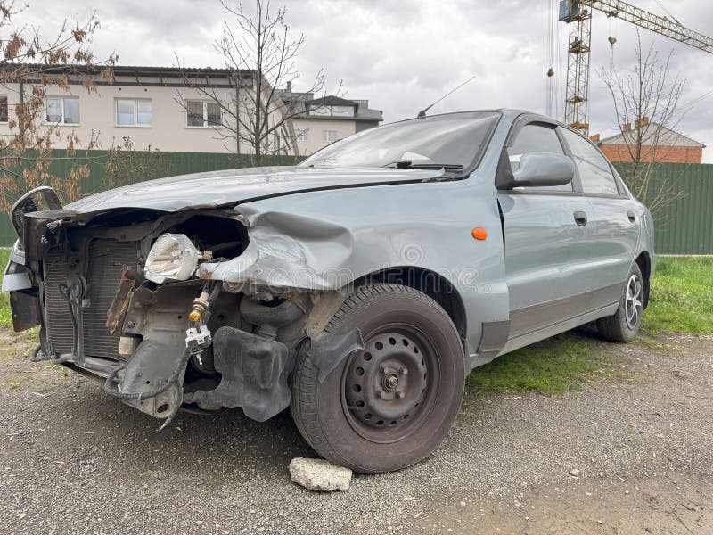 A Silver Car with Severe Front-end Damage is Parked Near a Construction ...