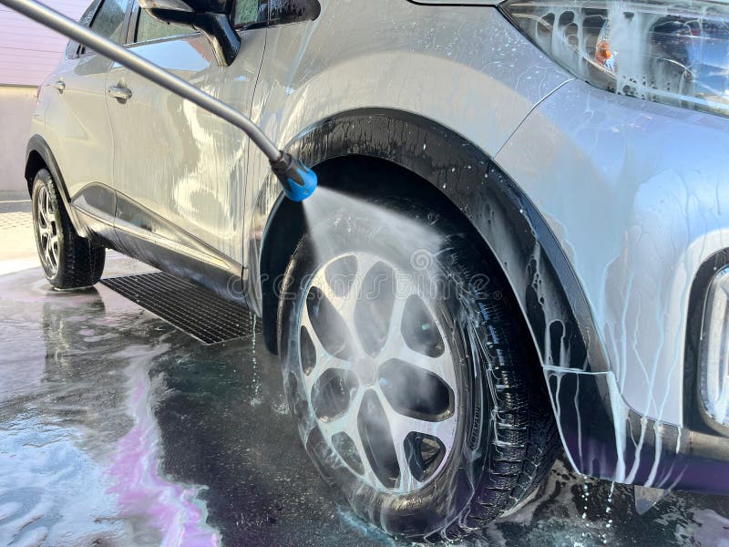 A Silver Car at a Car Wash after Cleaning with Active Foam, Wax is ...