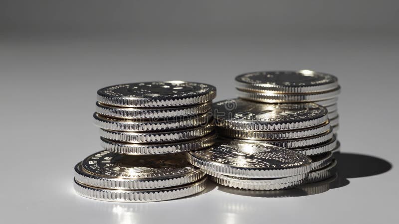 Silver Coins Spinning, Gleaming Against White Surface, Representing ...