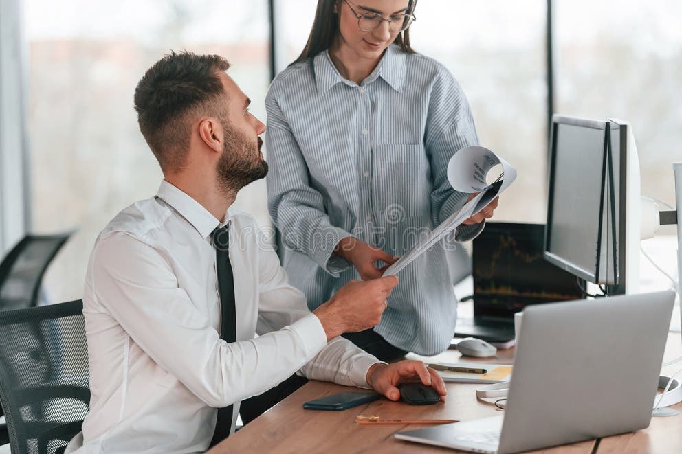 Silver Colored Laptop is on the Table. Two Employees are Working in the ...