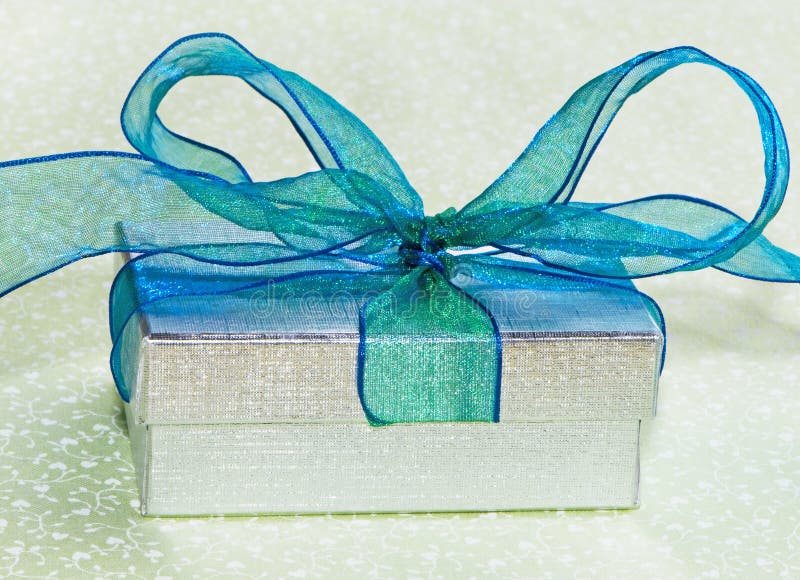 Silver Gift Box with Blue Bow on Green Tablecloth Stock Image - Image ...