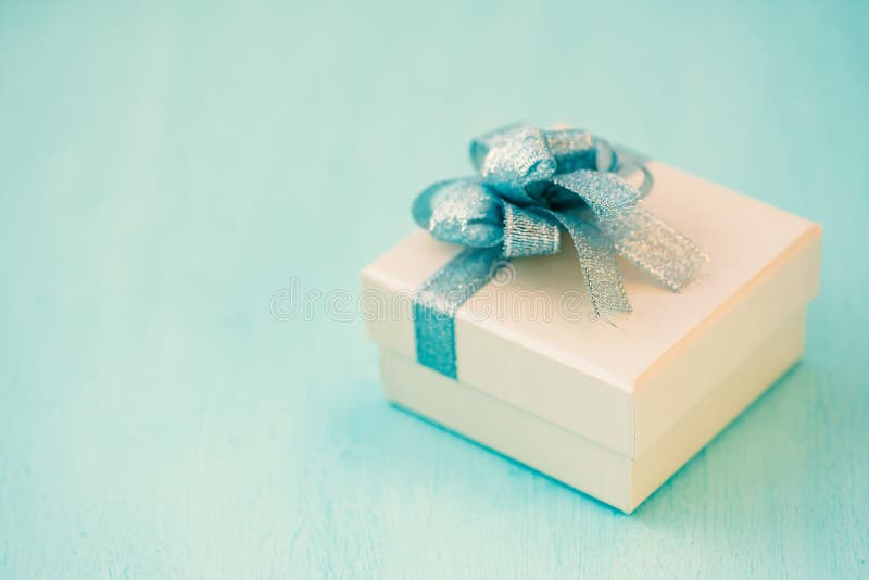 Silver Gift Box with Blue Ribbon on Blue Table Stock Image - Image of ...