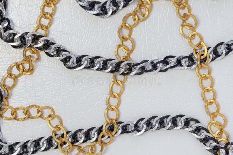 Silver and Gold Color Chains. Chains on White Leather Background Stock ...