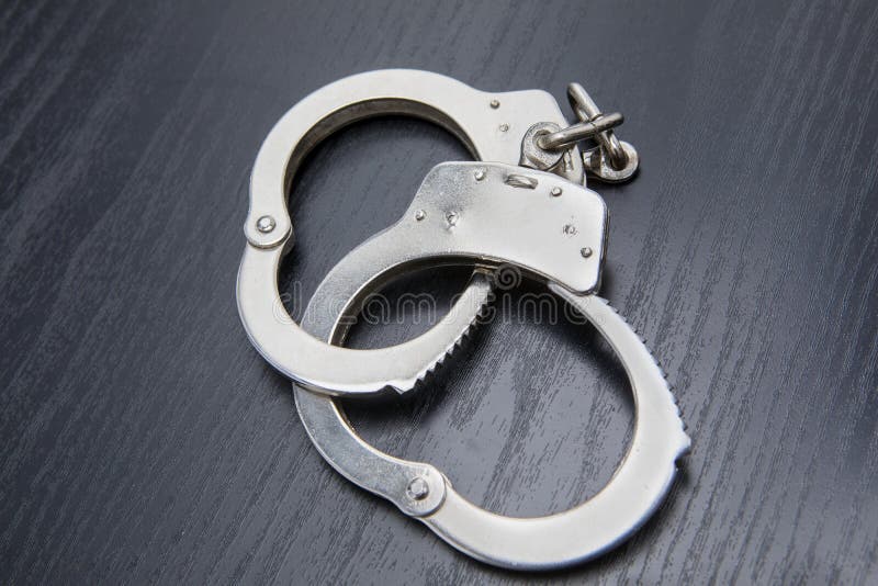 Silver Handcuffs Above Wooden Table Stock Photo - Image of black ...