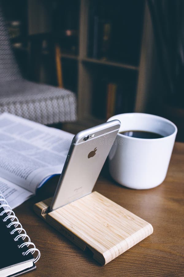 Silver Iphone On Brown Wooden Rack On Top Of Table Picture. Image ...