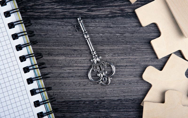 Silver Key with a Notepad and Puzzle Pieces on a Table Stock Photo ...