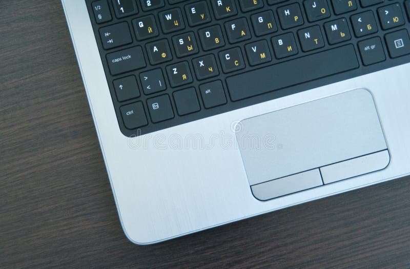 Silver Laptop on the Brown Wooden Table. Laptop Touchpad and a Keyboard ...