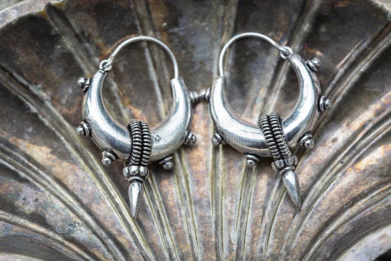 Metal Earrings on Decorative Silver Shell Background Stock Image ...