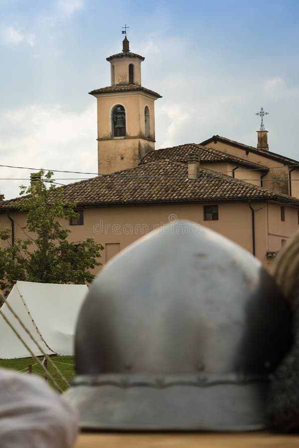 Silver and Metallic Knight Helmet, Bell Tower in Background Stock Photo ...