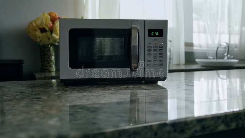 A Silver Microwave Sits on a Countertop in a Kitchen Stock Footage ...