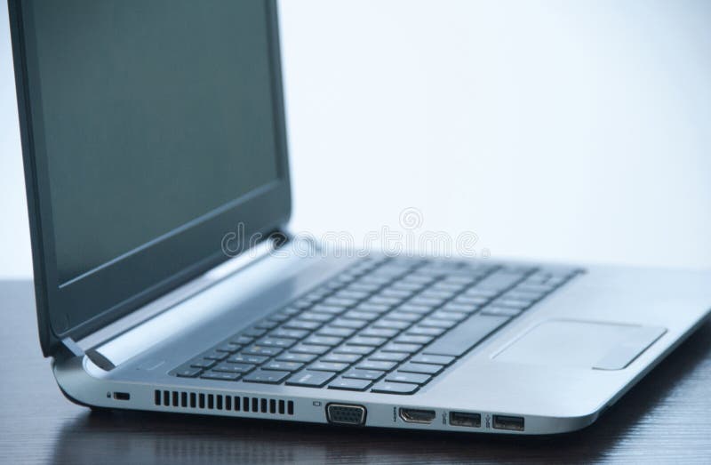 Silver Modern Laptop on a Brown Wooden Table. Side View Stock Image ...