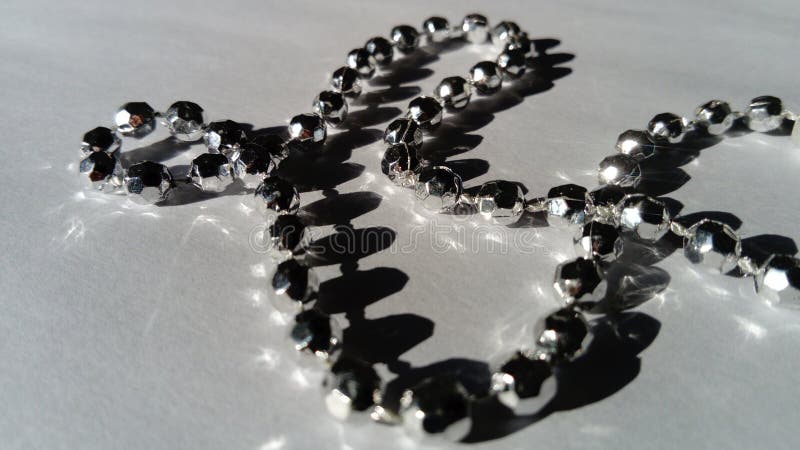 Silver Necklace with Reflections of Light on a White Background Stock ...