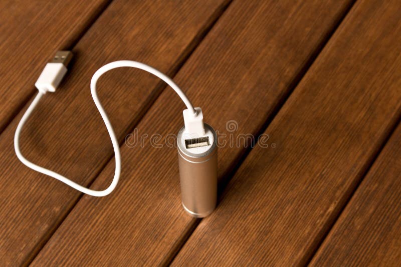 Silver Power Bank Charging Smartphone on Wooden Table Stock Image ...