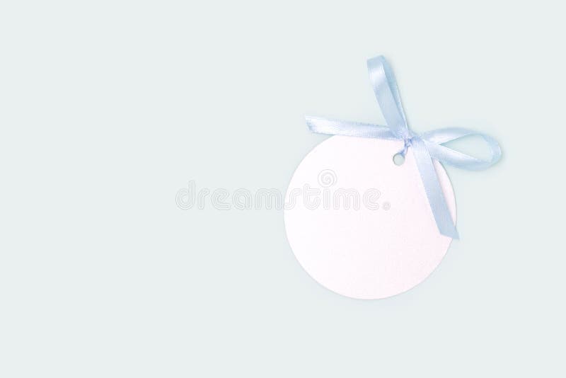 Silver Round Empty Tag with Tied Blue Ribbon Bow on a Yellow Background ...