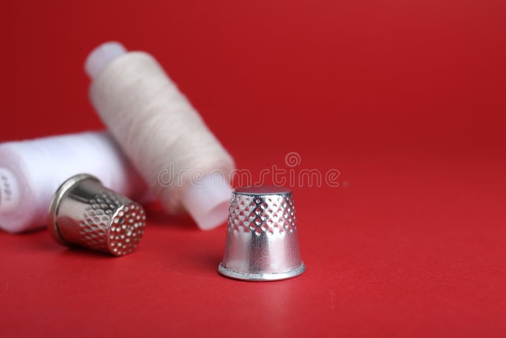 Silver Thimbles and Light Thread on Red Background. Sewing Accessories Stock Image - Image of ...