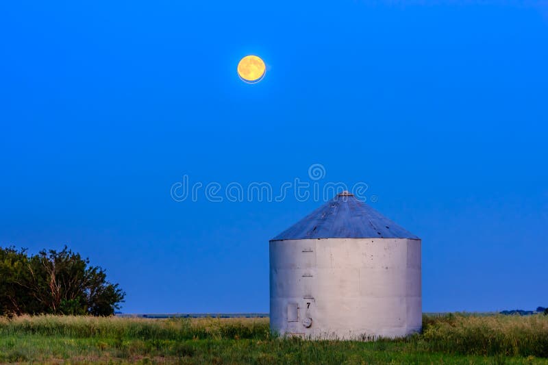 A Silvery Metal Silo is in a Field with a Full Moon in the Sky Stock ...