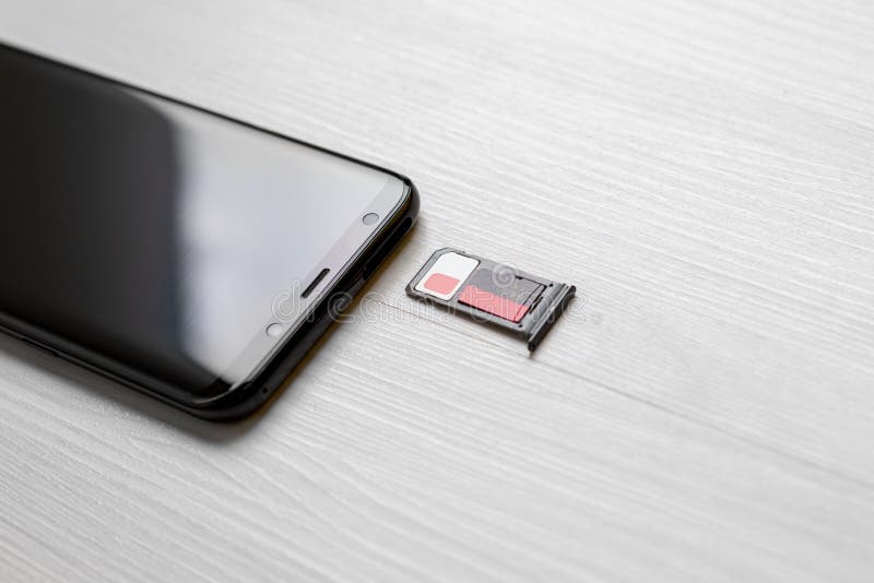 SIM Card and Memory Card in Adapter beside Smart Phone on Desk Close-up ...