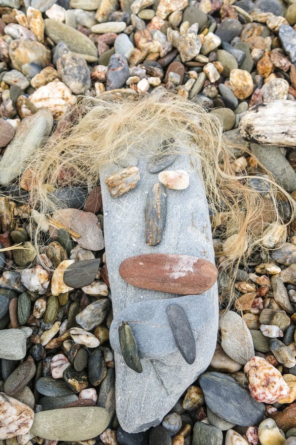 Simpatic Face Created on a Beach with Small Stones and Dried Algae ...