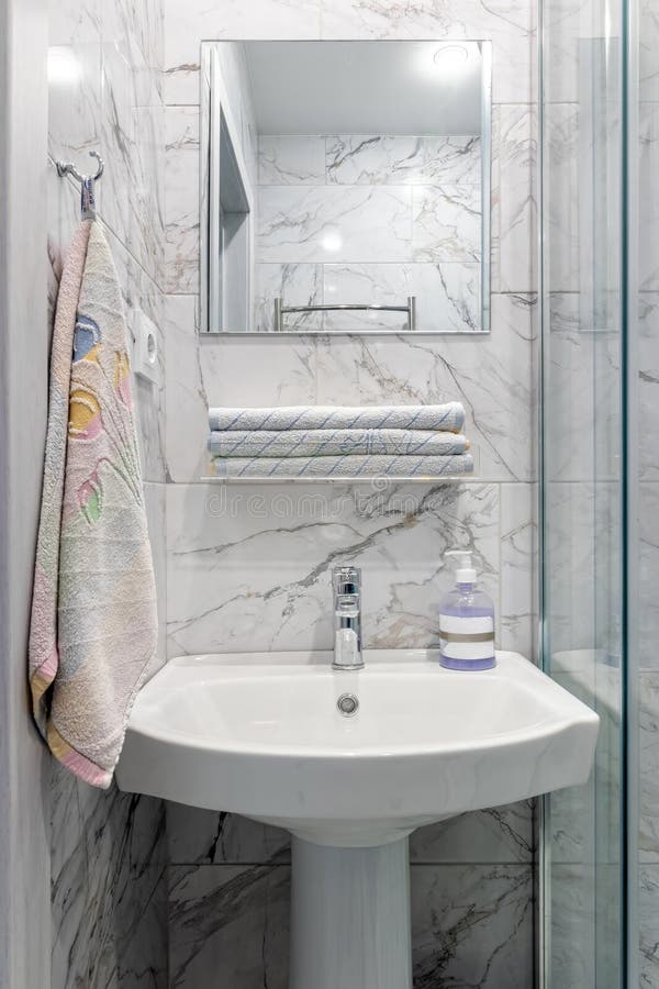 A Simple Bathroom with a Silver Shower, a Square Mirror and Classic ...