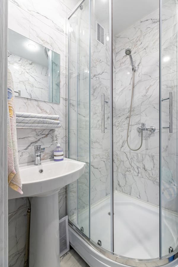 A Simple Bathroom with a Silver Shower, a Square Mirror and Classic ...