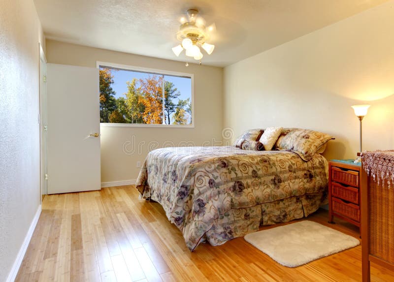 Simple Bedroom with Hardwood Floor and Fall Window View. Stock Photo ...