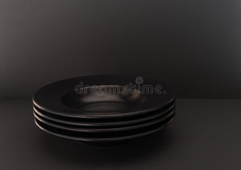 A Simple Composition of a Stack of Black Plates on a Black Background ...