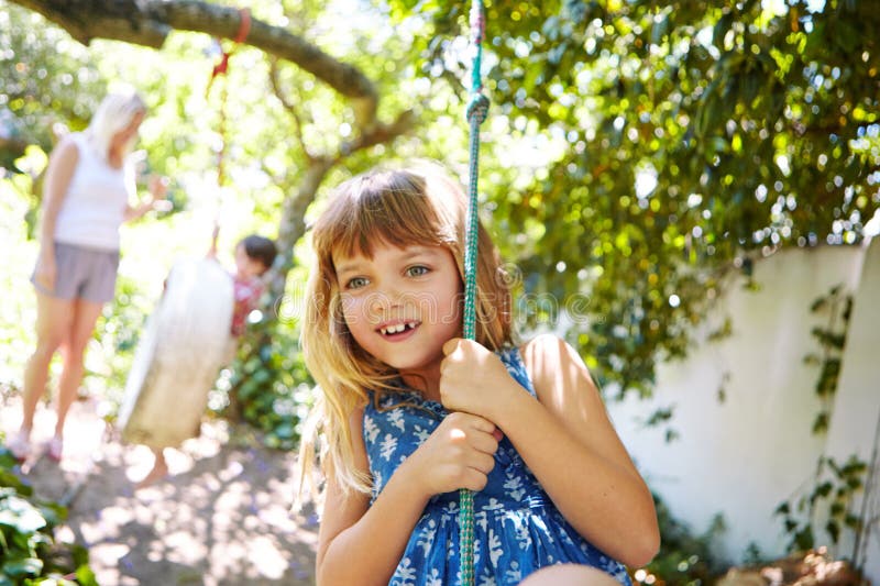 The Simple Joys of Swinging. a Young Girl Swinging in the Yard. Stock ...