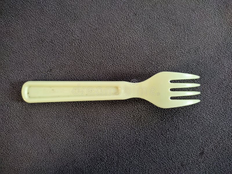 Simple Pale Yellow Plastic Fork on Dark Textured Surface Stock Image ...