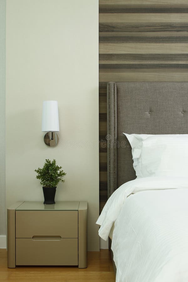 Simple Side Table with a Small Plant and Wall Mounted Lamp Above it ...