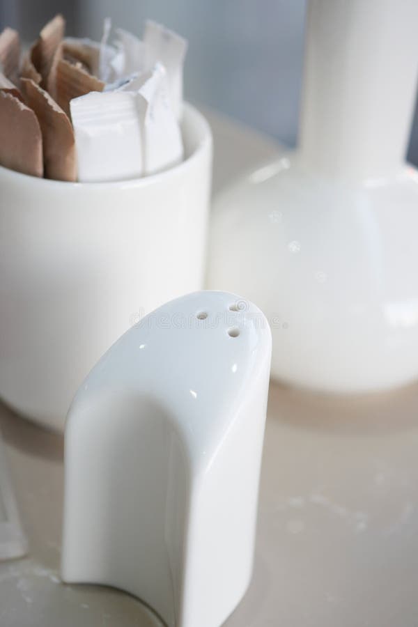 Simple White Salt Shaker and Sugar Packets on a Table Stock Image ...