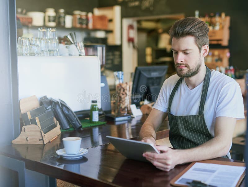 Simplifying Business with Technology. a Young Barista Using a Tablet in ...