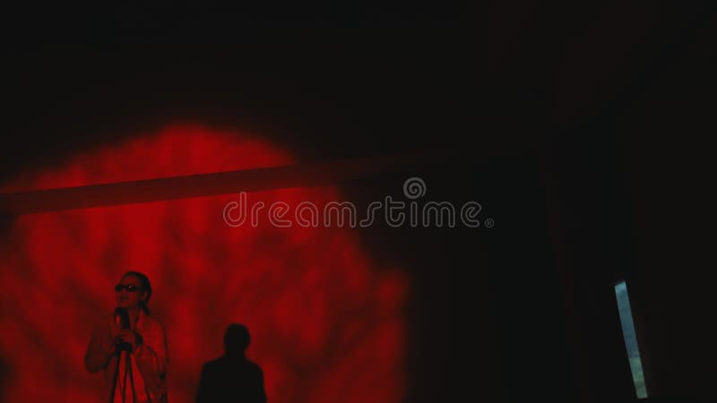 Singer Performing on Stage with Red Spotlight and Shadow Silhouette ...