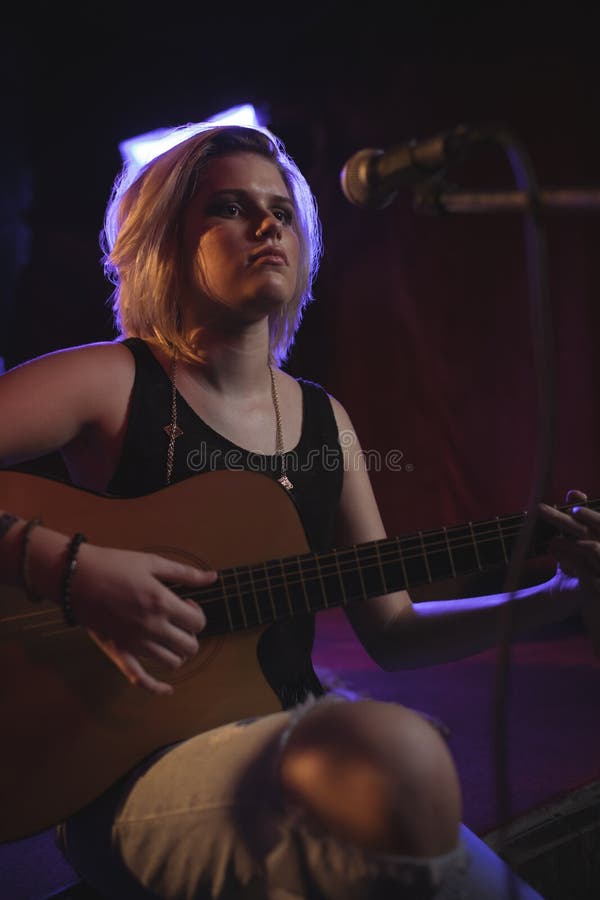 Singer Practicing with Guitar in Nightclub Stock Photo - Image of ...