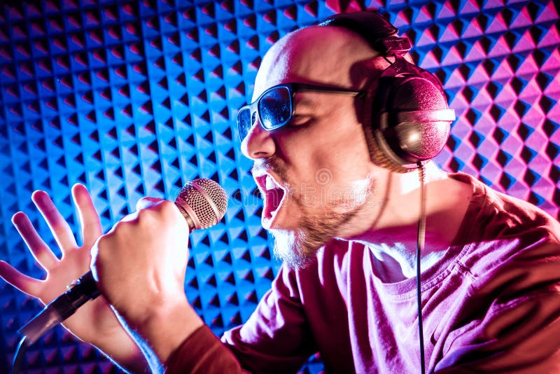 The Singer Sings with a Microphone in the Recording Studio. Stock Photo ...