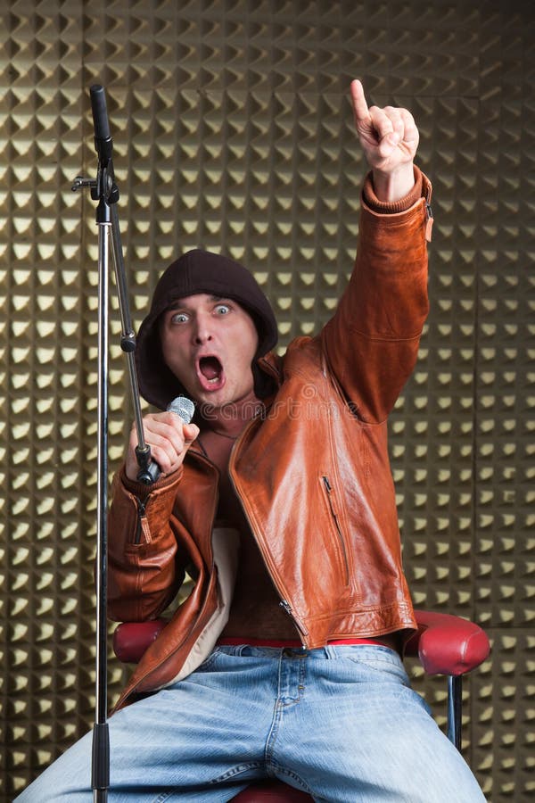Man Singer Sitting on a Stool in a Headphones with a Guitar Recording a ...