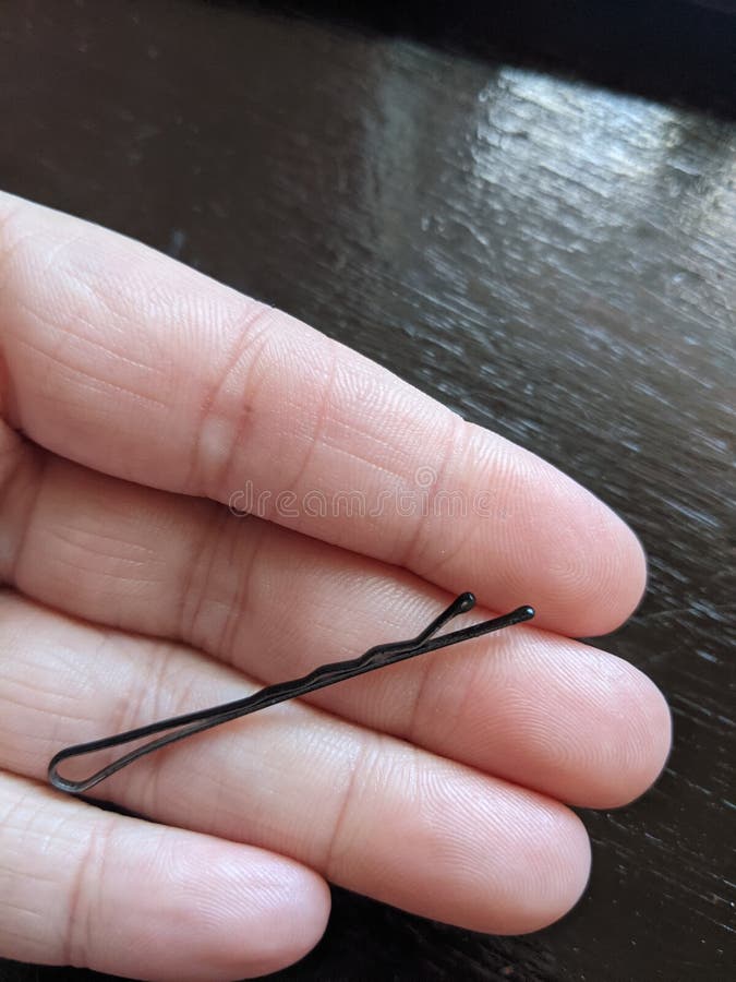 Single bobby pin in hand stock image. Image of care - 203819477