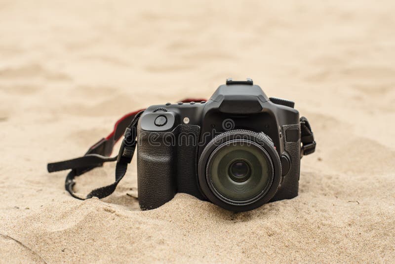 Single Camera Lying on a Sandy Beach Stock Image - Image of water ...
