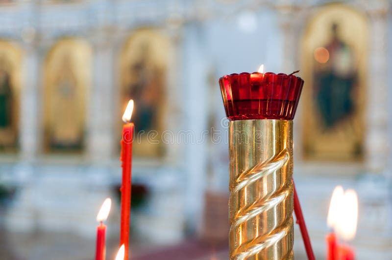 Single Candle with Dripping Wax and Blurring Lights of Many Candles in ...