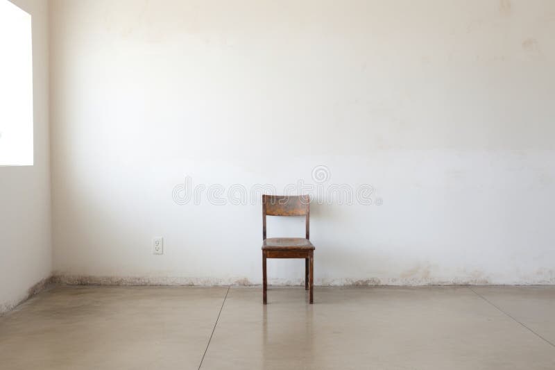 A Single Chair in an Empty Room with Stark White Walls Stock Photo ...