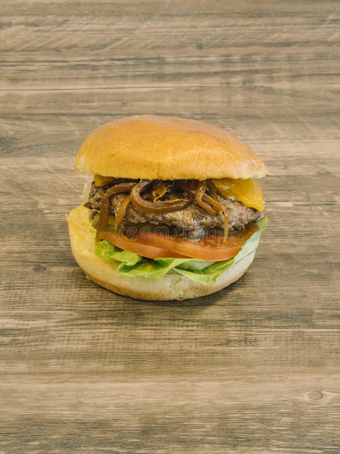 Single Cheese Burger with Caramalised Onions on Wooden Table Stock ...