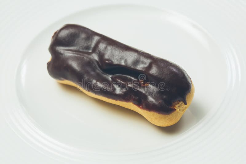 Single Chocolate Eclair on White Plate Stock Image - Image of ...