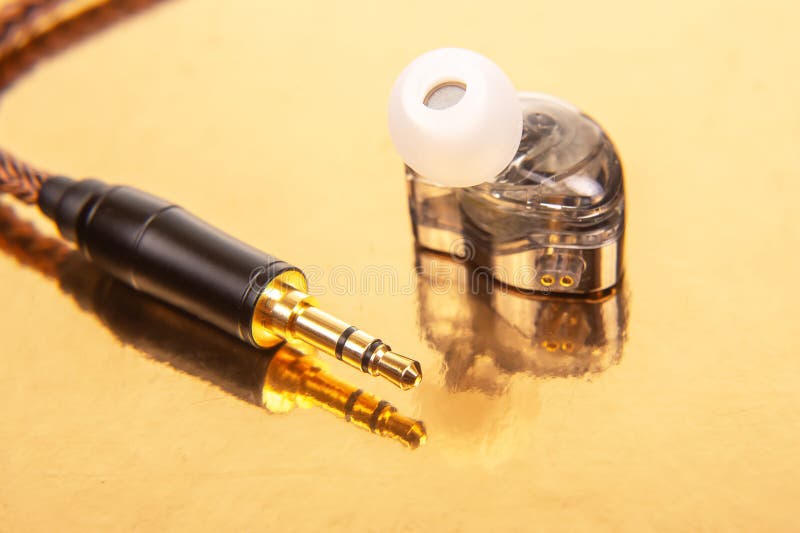 A Single Earbud with a White Tip, a 3.5mm Audio Jack, and a Black Audio ...