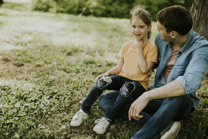 Single Father Sitting on Grass by the Tree with Little Daughter Stock ...