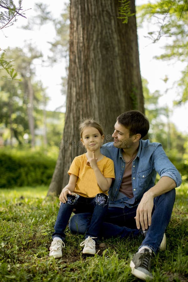 Single Father Sitting on Grass by the Tree with Little Daughter Stock ...