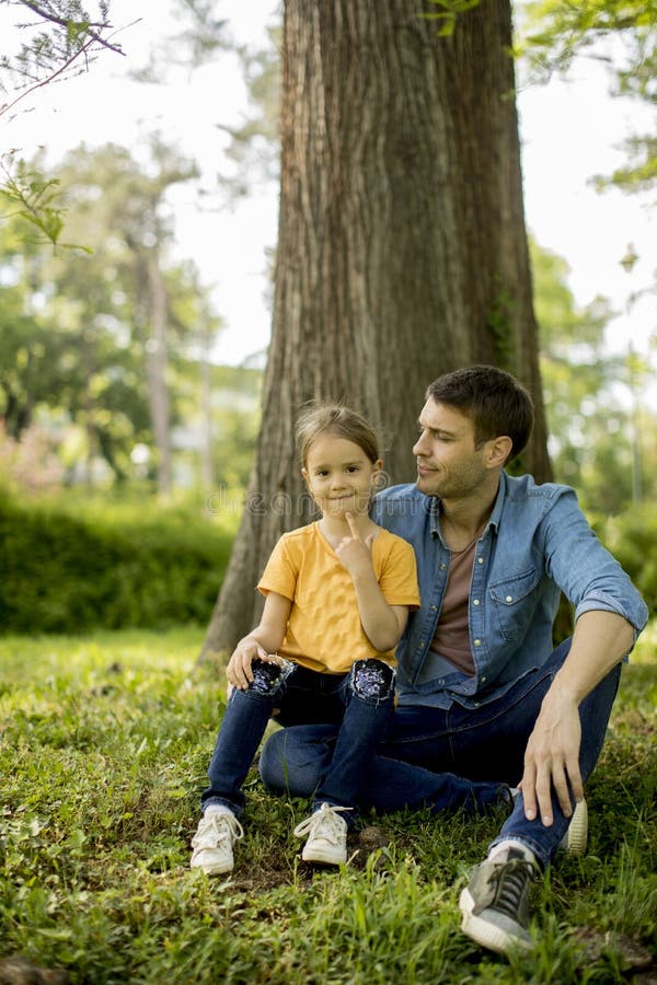 Single Father Sitting on Grass by the Tree with Little Daughter Stock ...