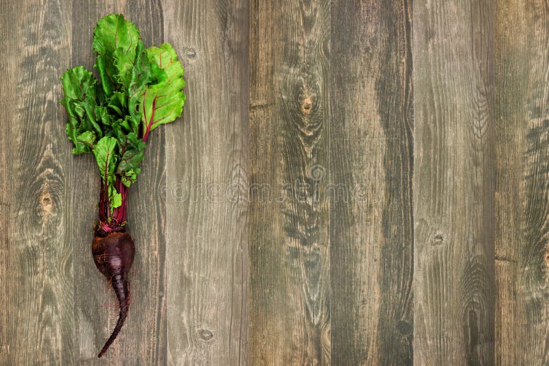 Single Beetroot with Leaves Over Rustic Wood Stock Image - Image of ...