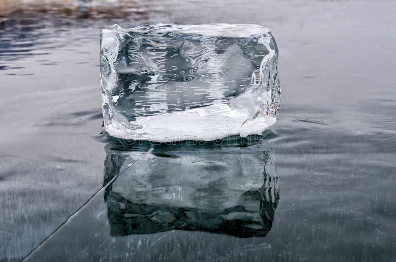 Single Ice Cube with Reflection on the Lake Surface Stock Photo - Image ...